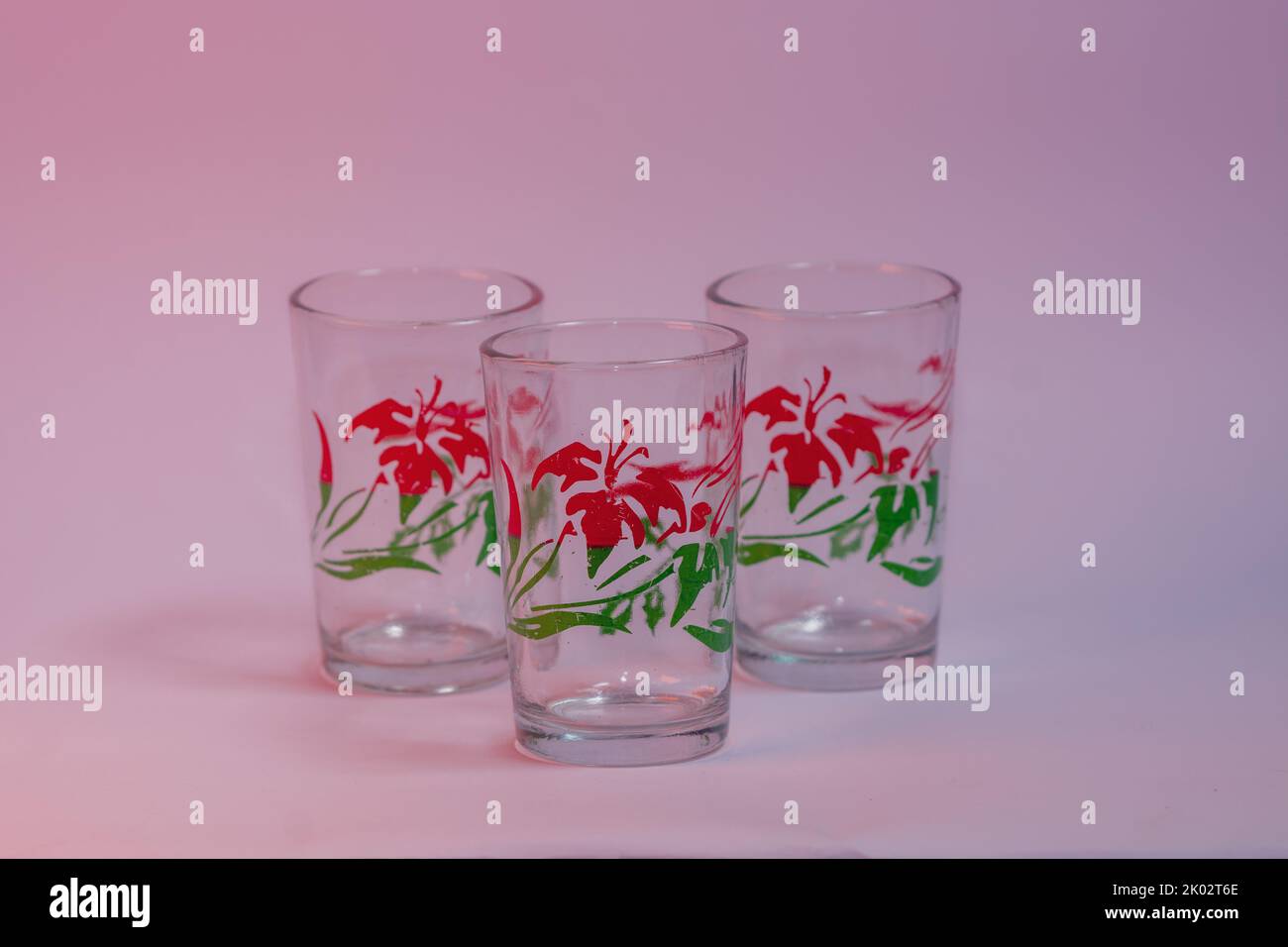 The three empty glasses with floral patterns isolated on pink ...