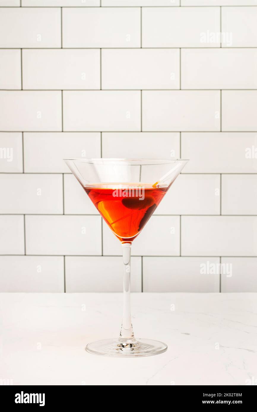 A glass of red vermouth on a marble countertop and in front of a subway ...