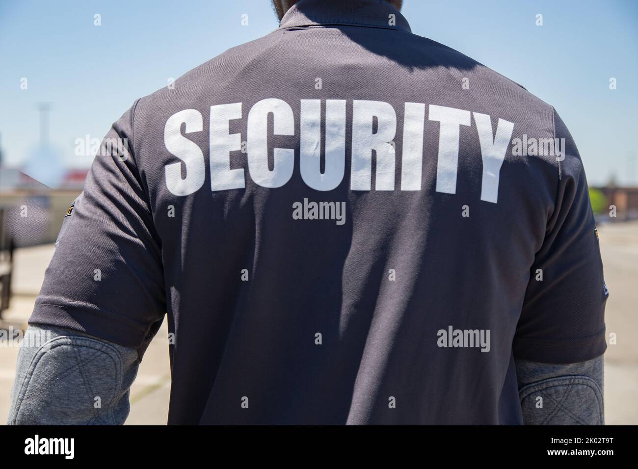 The security person standing outdoors in the sun, shot from back Stock ...