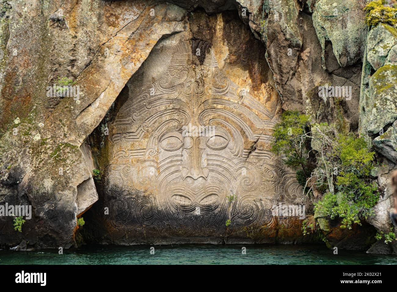 The view of Mine Bay Maori Rock Carvings by the water Stock Photo - Alamy