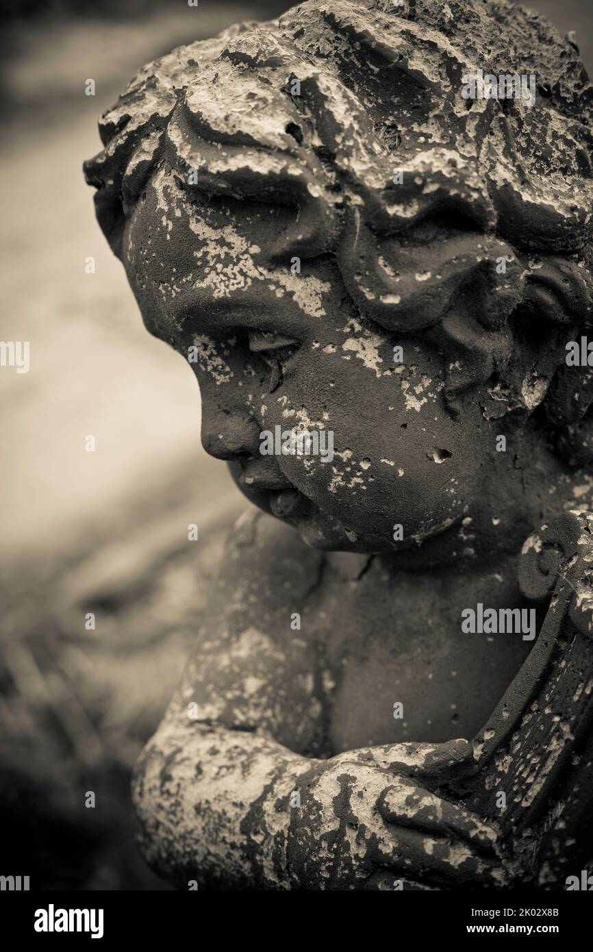 Weathered statue with child face Stock Photo - Alamy