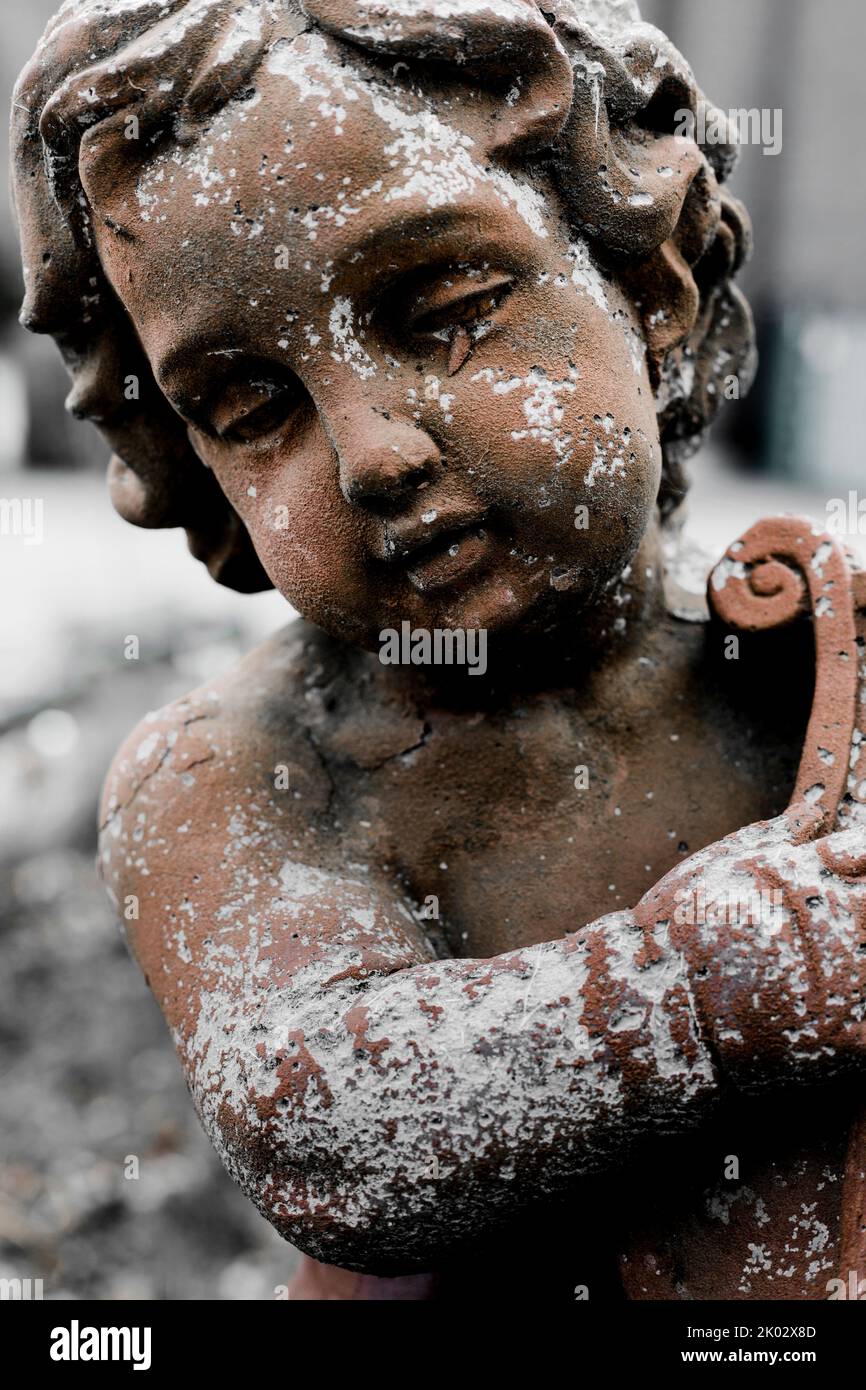 Weathered statue with small angel harp Stock Photo - Alamy