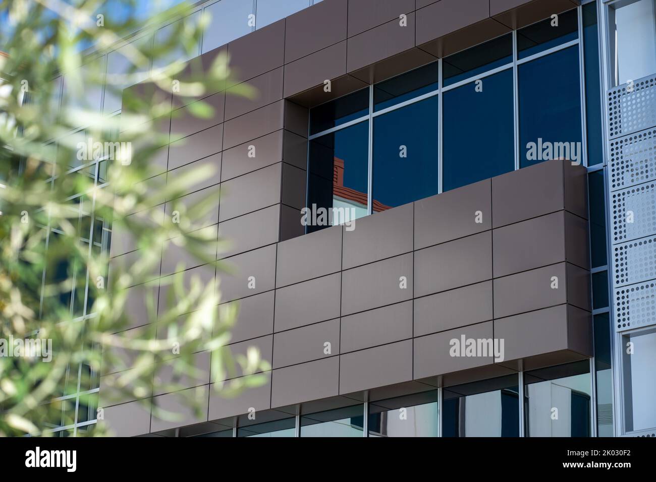 A building's facade cladding with composite panels and glass windows ...