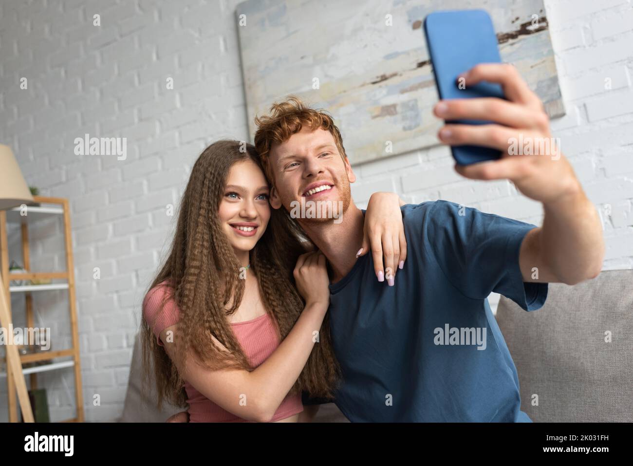Young And Happy Man Taking Selfie With Positive Girlfriend In Living Roomstock Image Stock