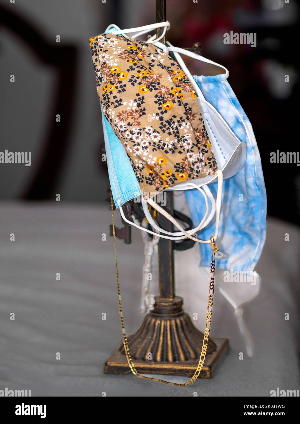 A face mask hanging on a golden stand Stock Photo - Alamy