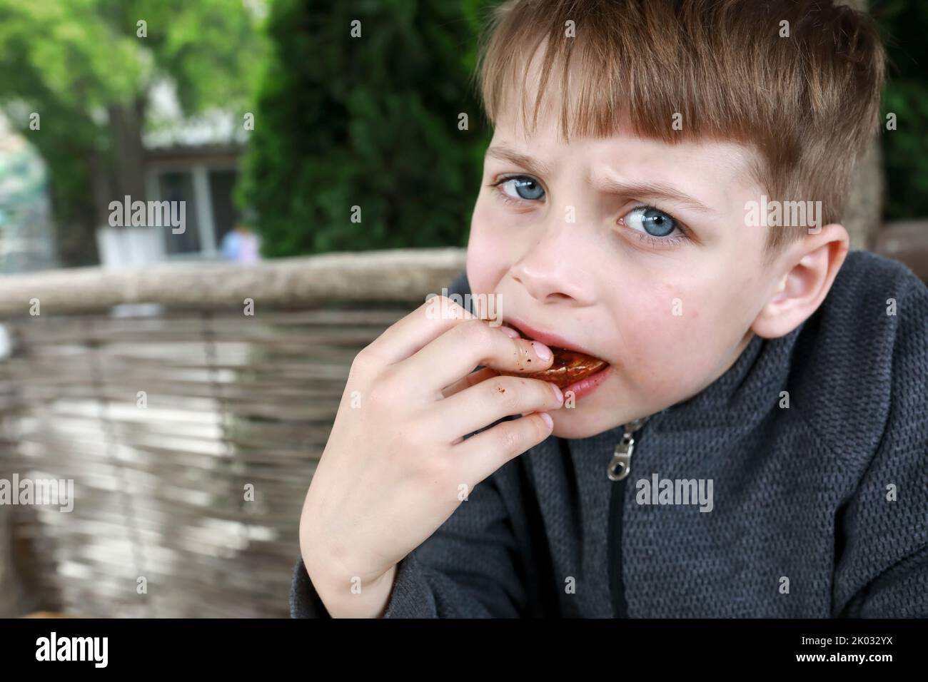 Child eating grilled potato on restaurant terrace Stock Photo - Alamy