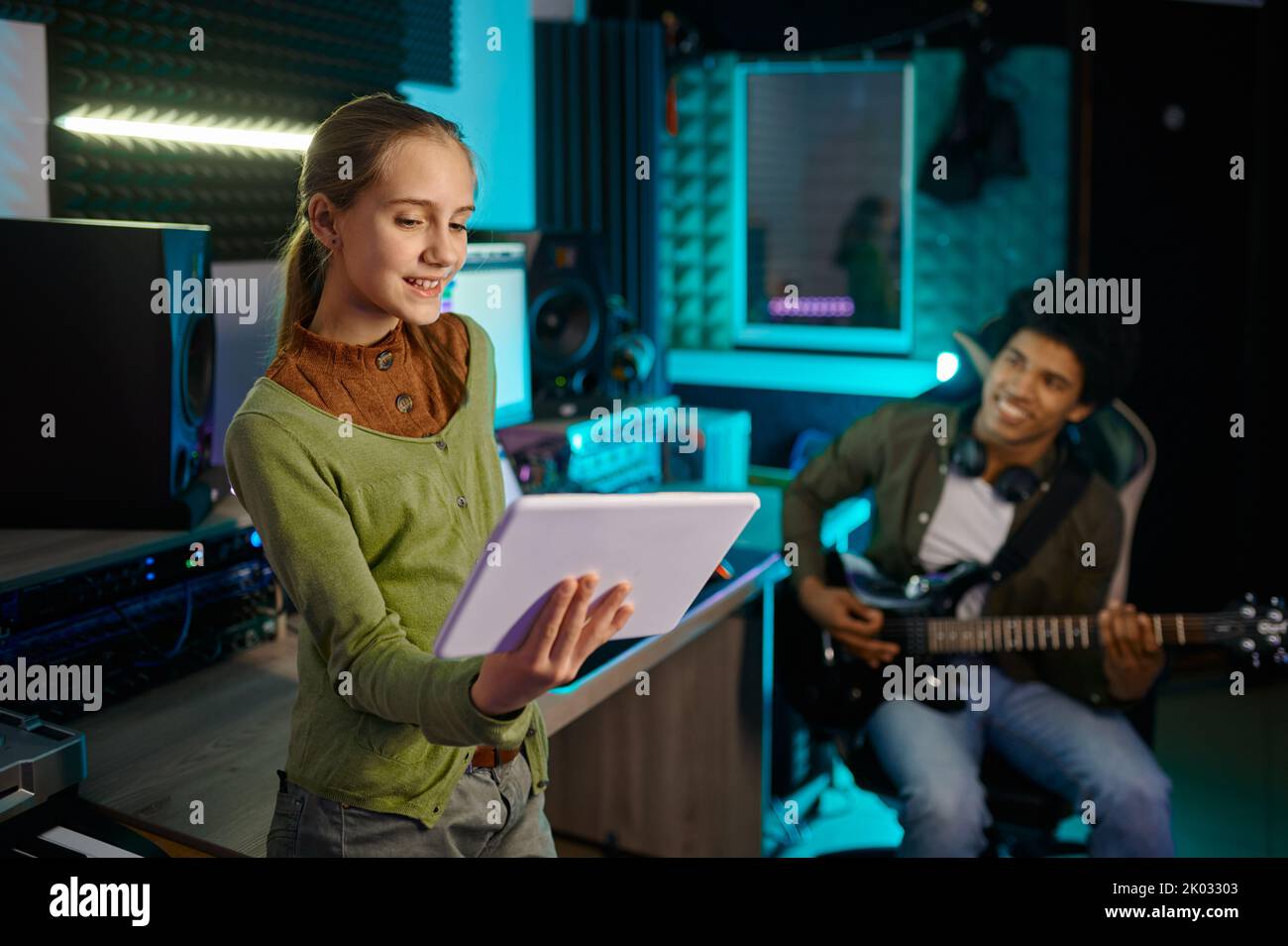Young girl singing song mixing track with man guitarist Stock Photo - Alamy