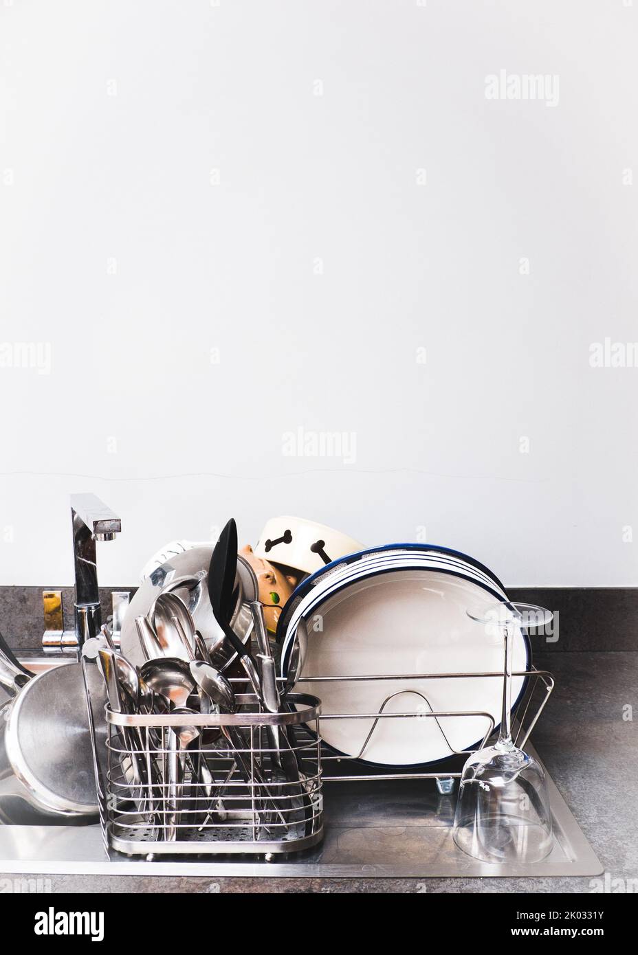 A vertical of clean dishes drying after washing Stock Photo - Alamy