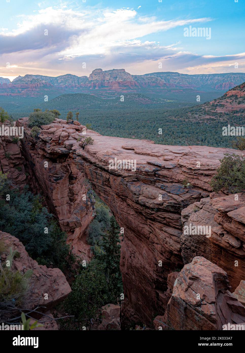 A vertical shot of Devils bridge at Sedona Arizona with mountains and a ...