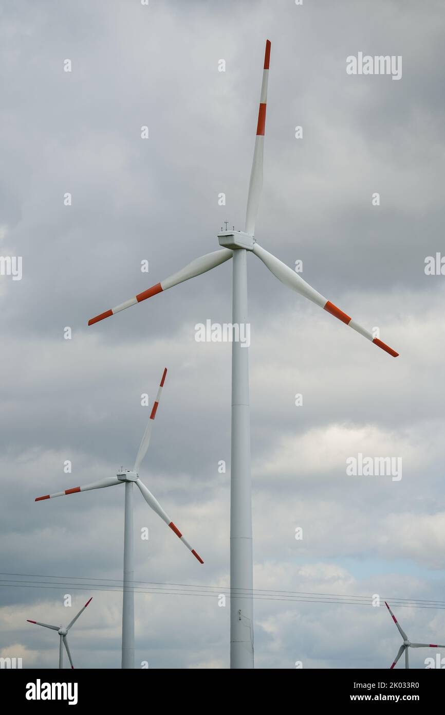 A vertical closeup of windmill energy power station with background of ...