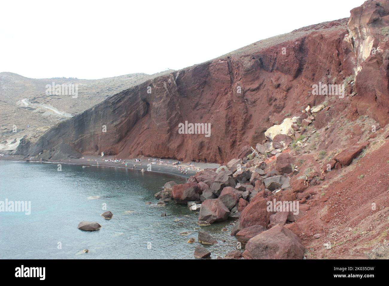 A giant coastal cliff with red stones and rocks Stock Photo - Alamy