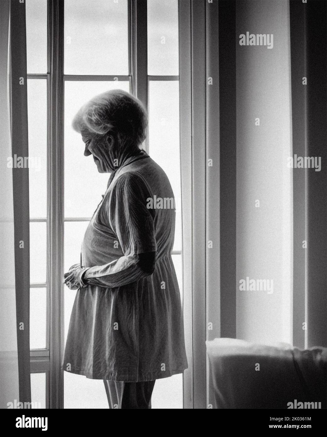 An elderly woman looking out of a window Stock Photo - Alamy