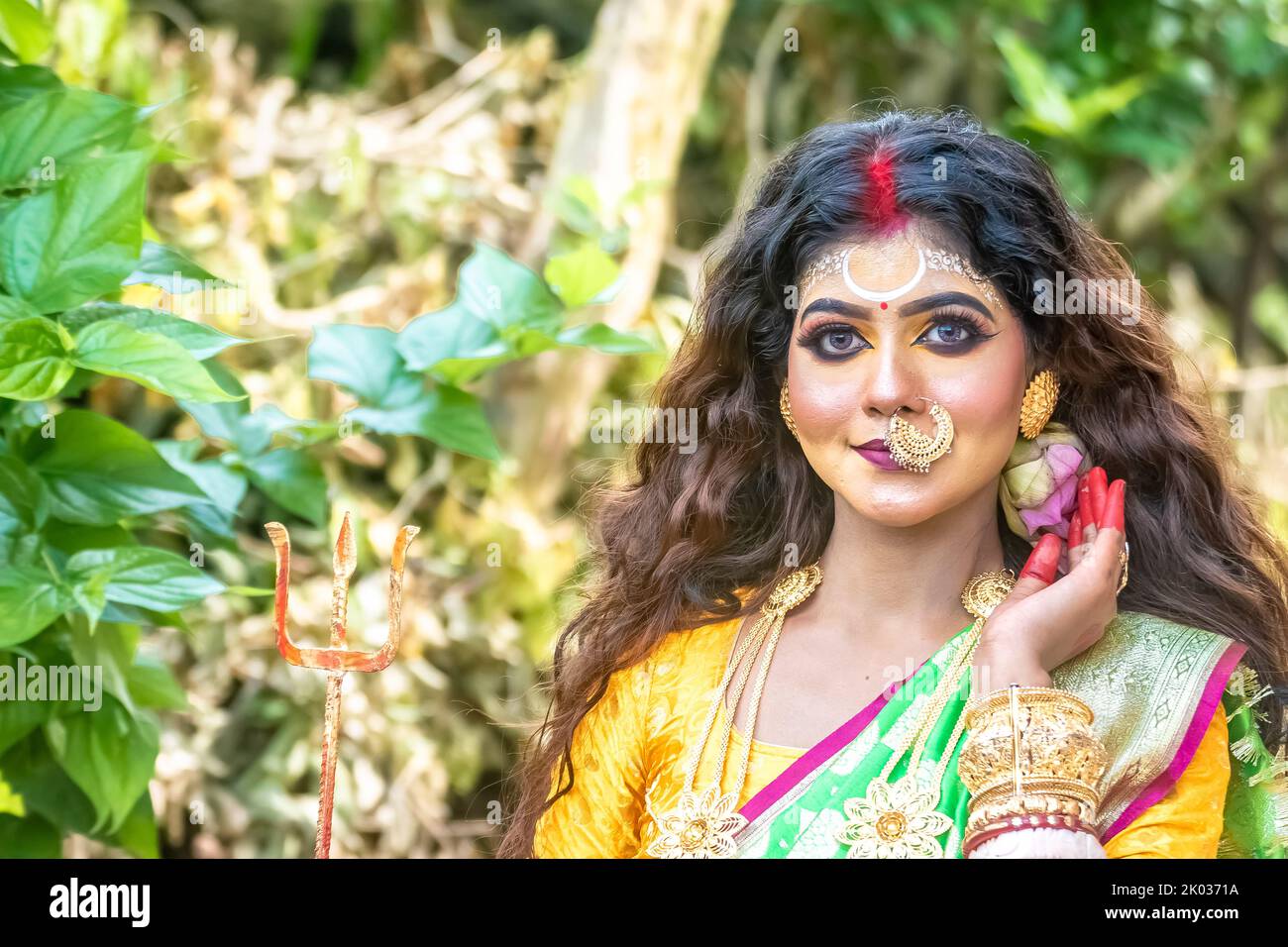 Concept Agomoni shoot with black haired Indian brunette woman face with ...