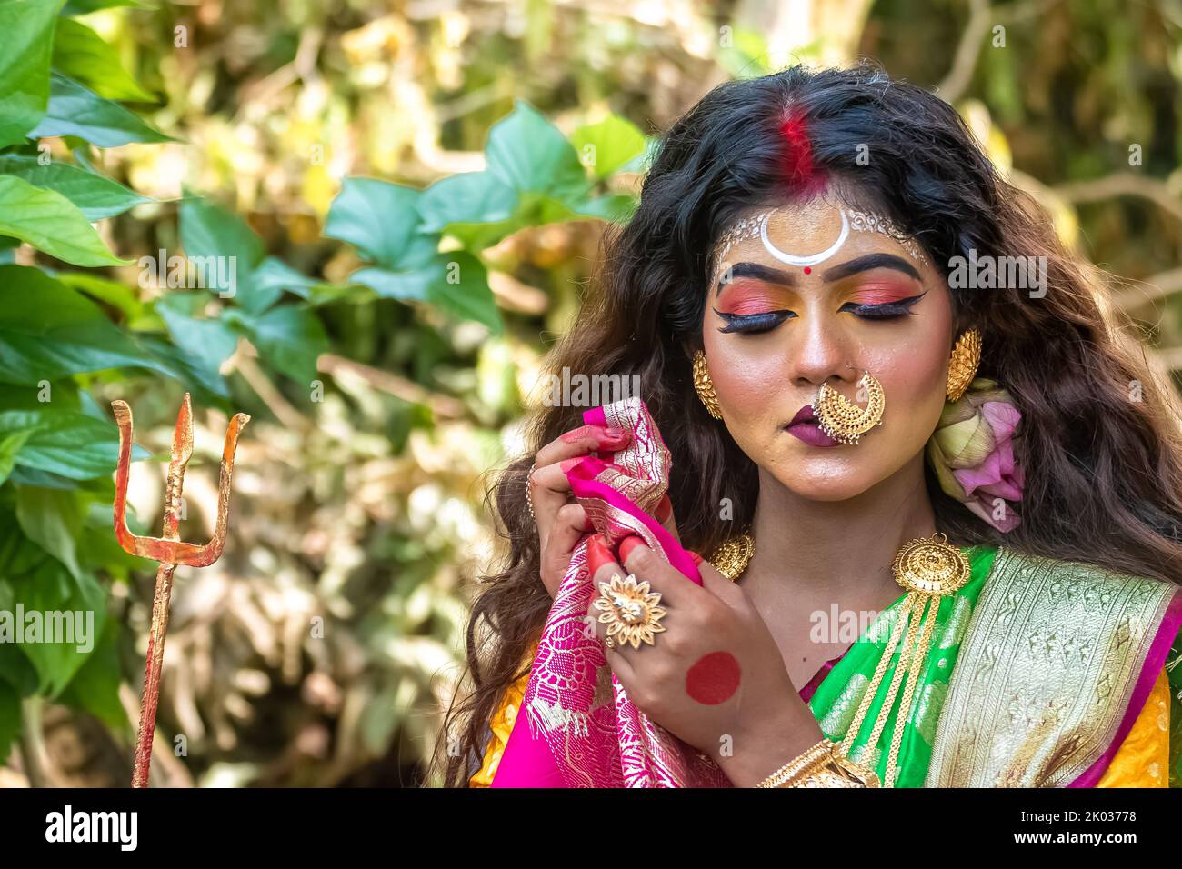 Concept Agomoni shoot with black haired Indian brunette woman face with ...