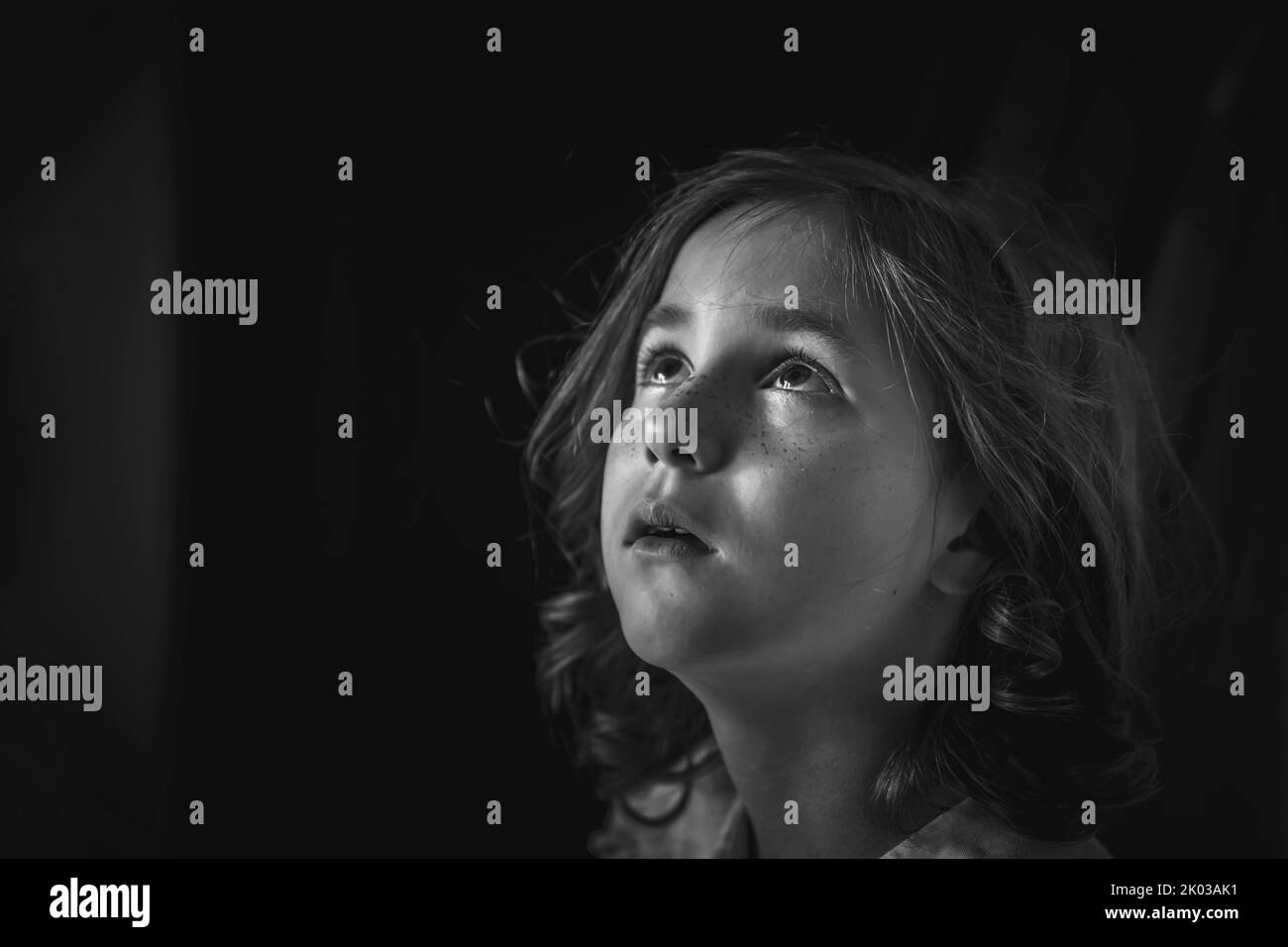 a little girl sits alone in a dark hallway. fear, loneliness Stock ...