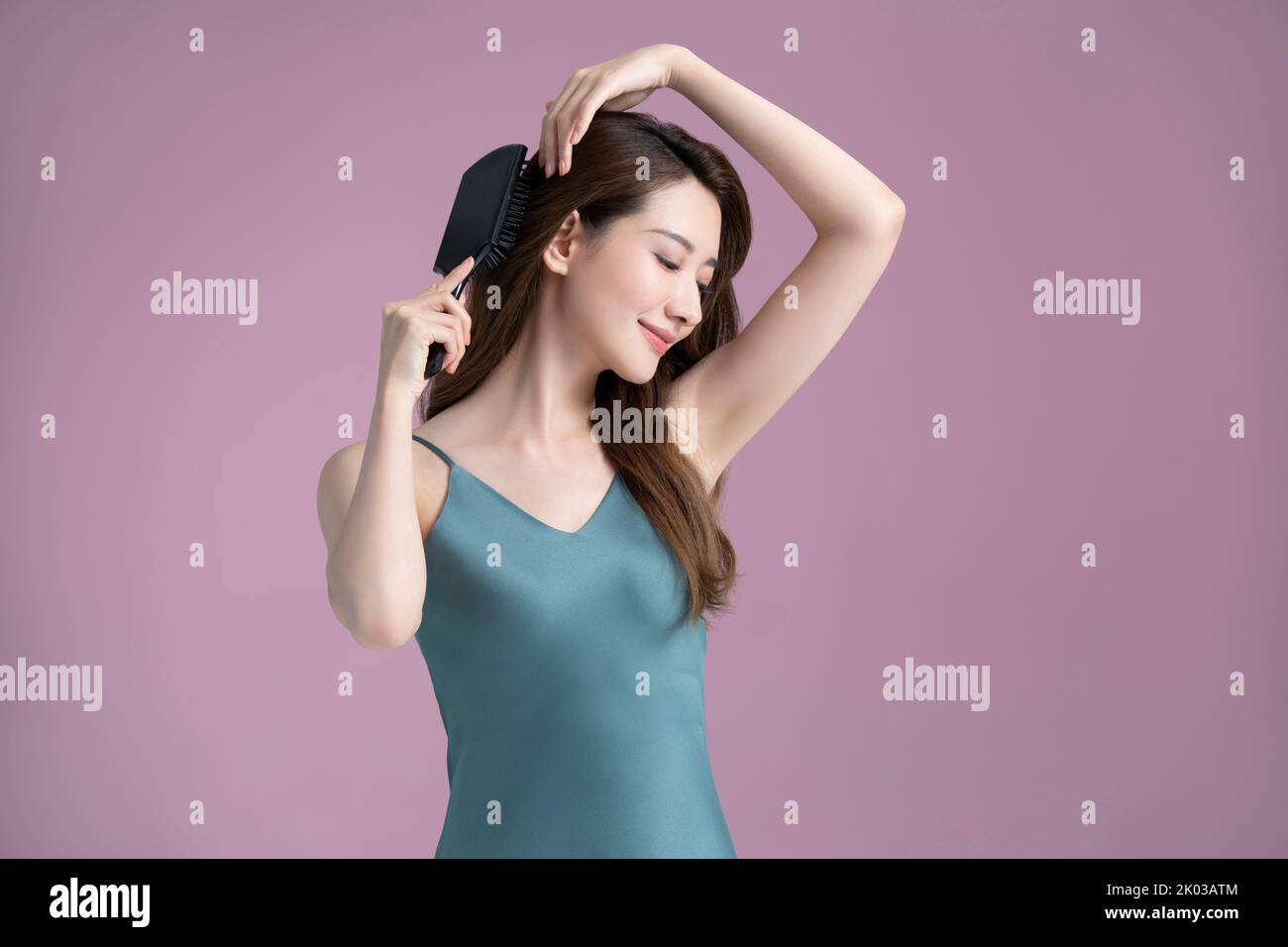 Beautiful young Chinese woman combing long hair Stock Photo - Alamy