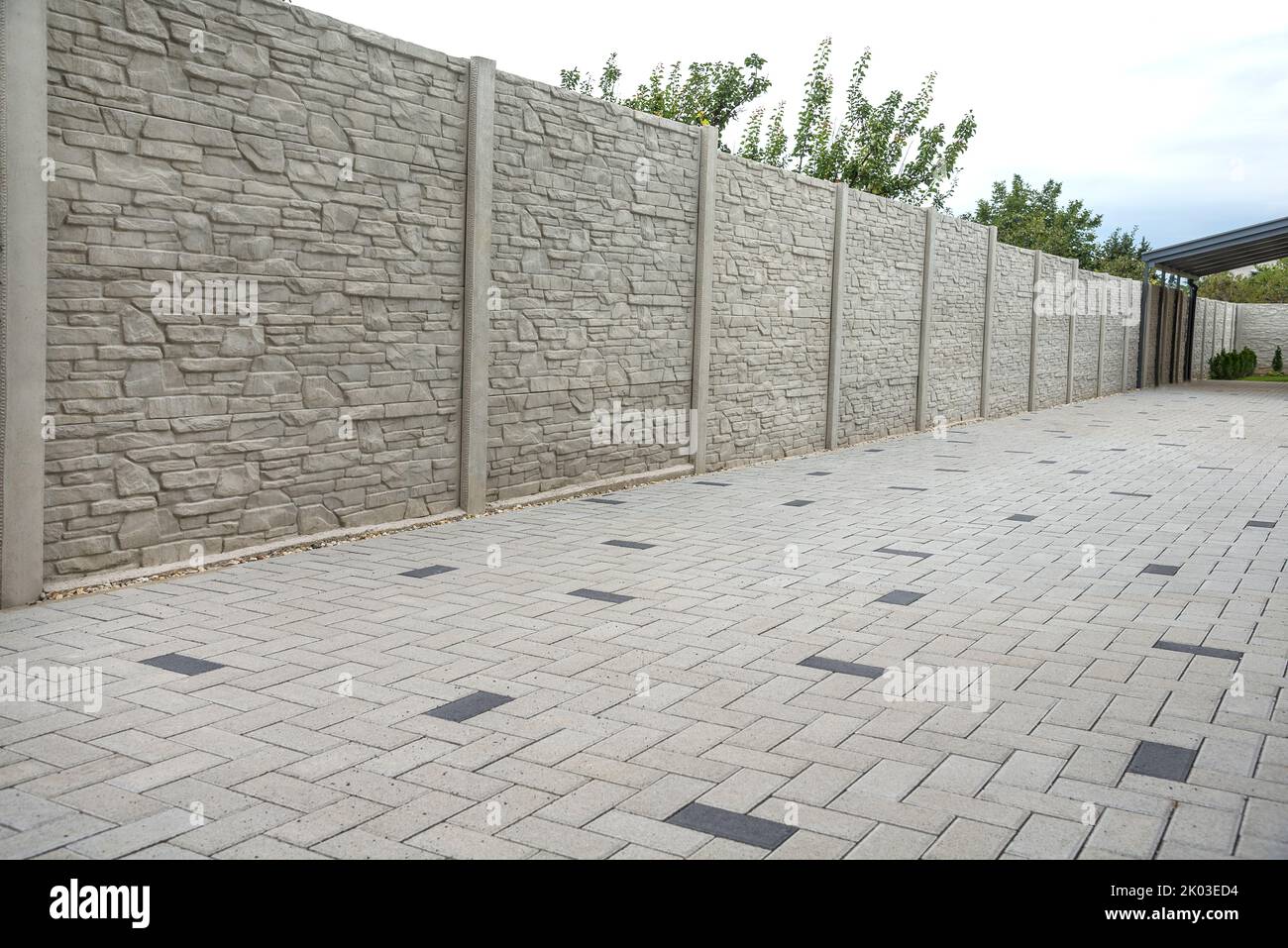 Concrete pattern fence and block paving tiles Stock Photo - Alamy