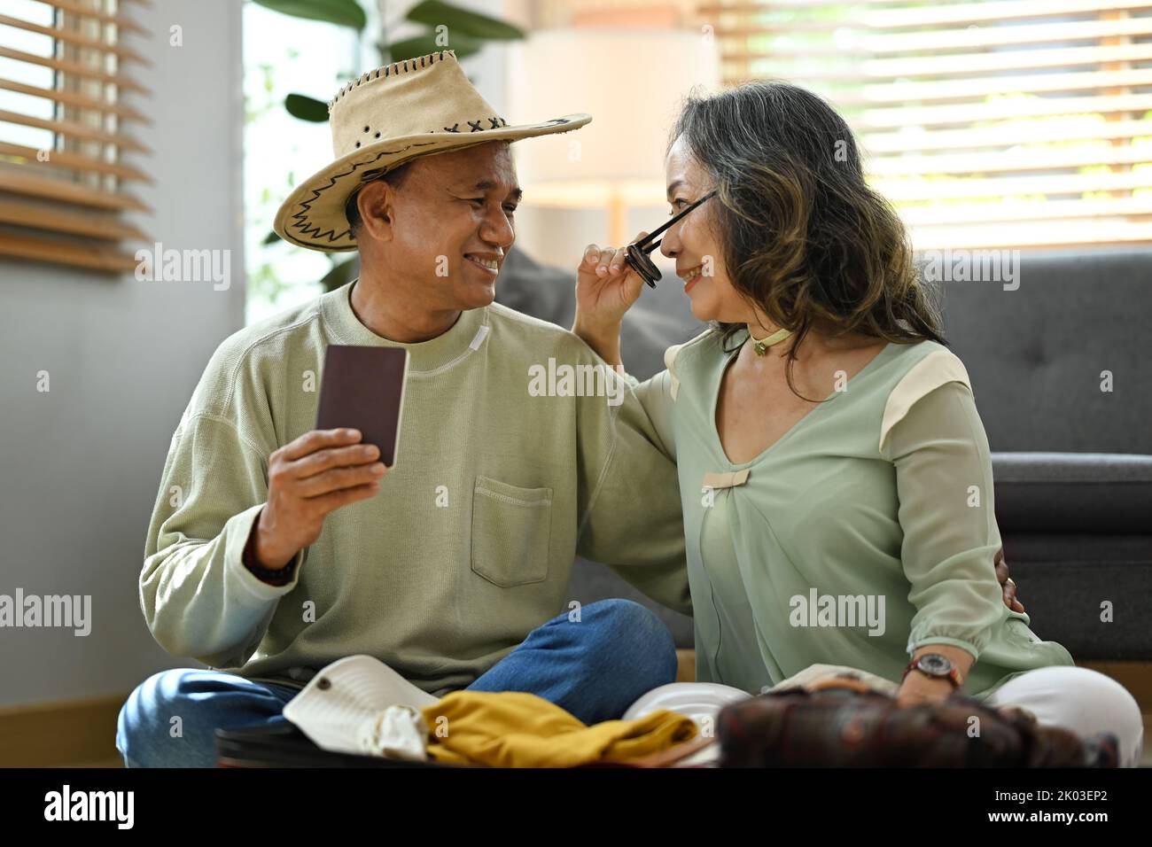 Happy retired couple packing cloth and stuff, getting ready for summer ...