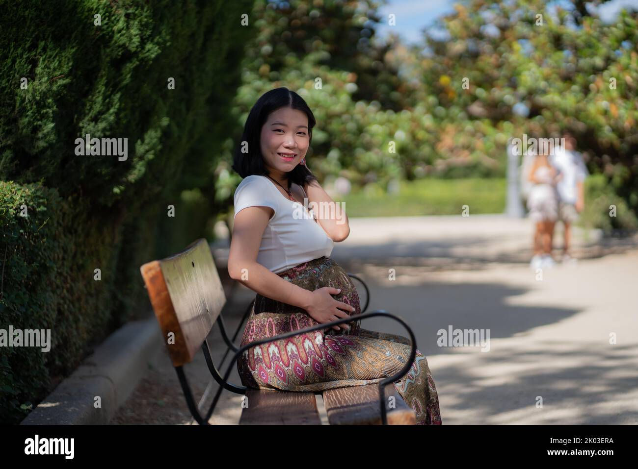 young happy and beautiful Asian Korean woman pregnant showing her belly ...