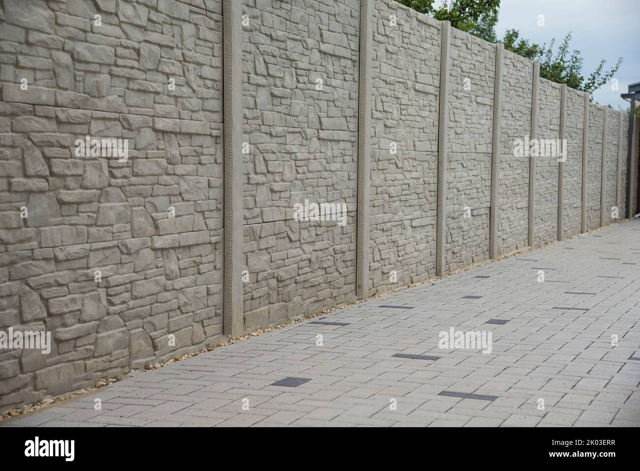Concrete pattern fence and block paving tiles Stock Photo - Alamy