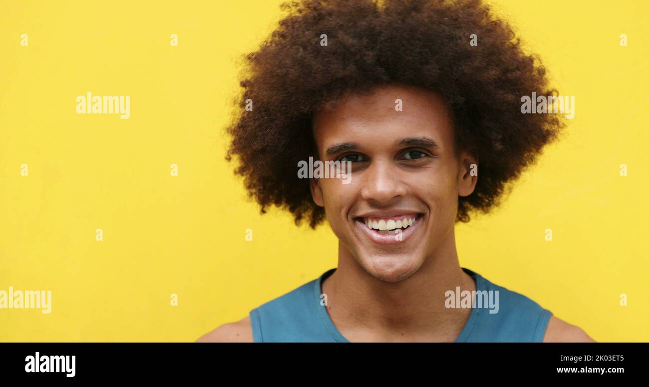 African american Mixed race young man smiling in yellow background ...