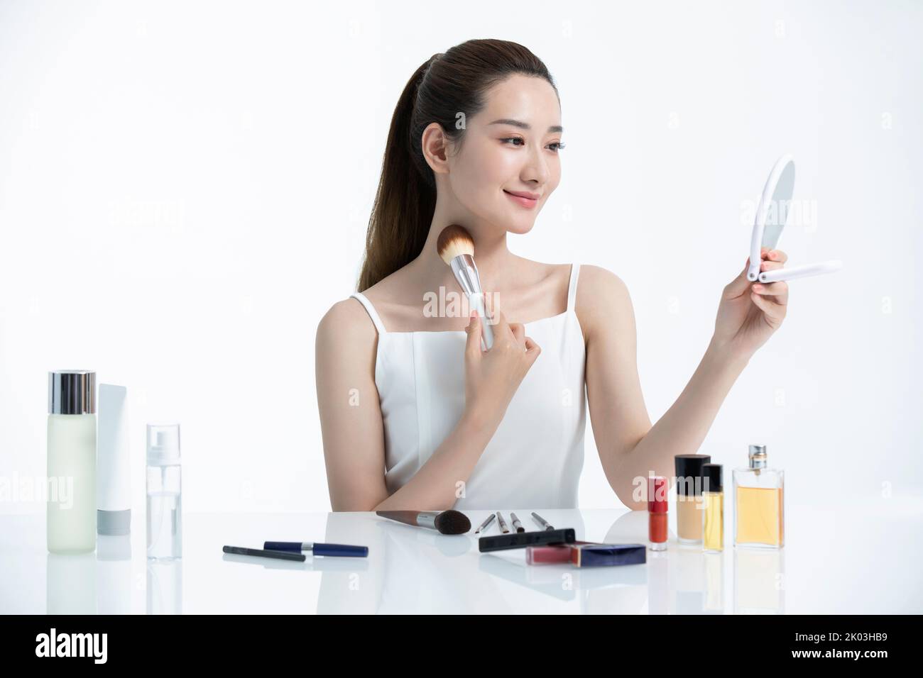 Beautiful young Chinese woman applying makeup Stock Photo - Alamy