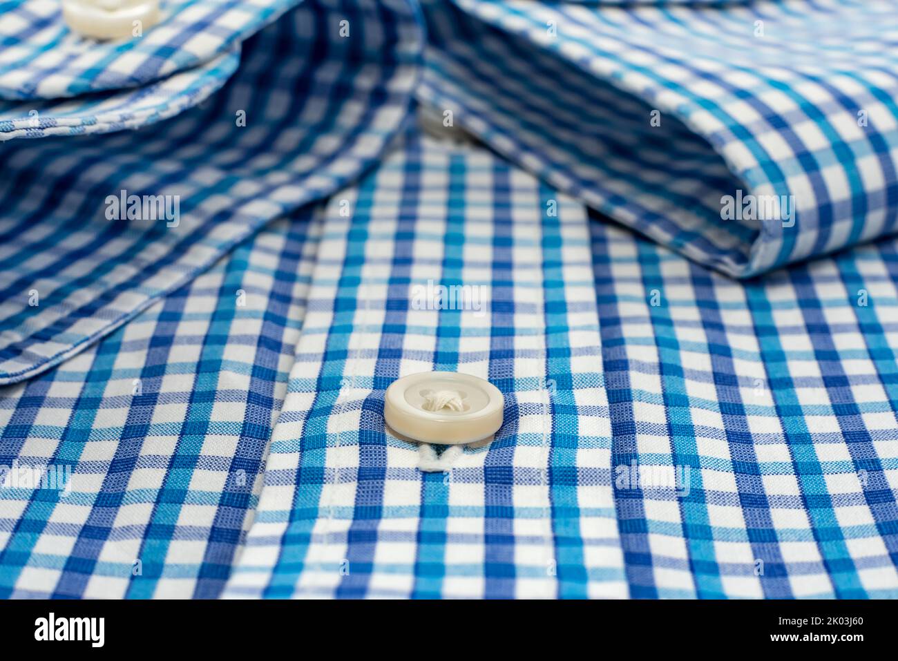 Buttons on the sleeve of the shirt in blue checkered material. Button ...