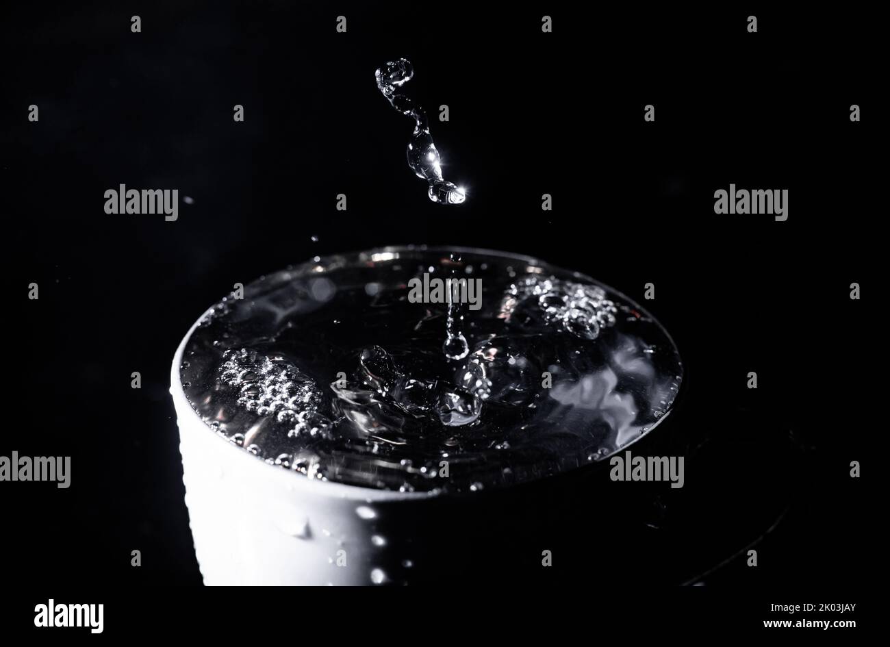 Cup with a falling drop of water close-up on a black background Stock ...