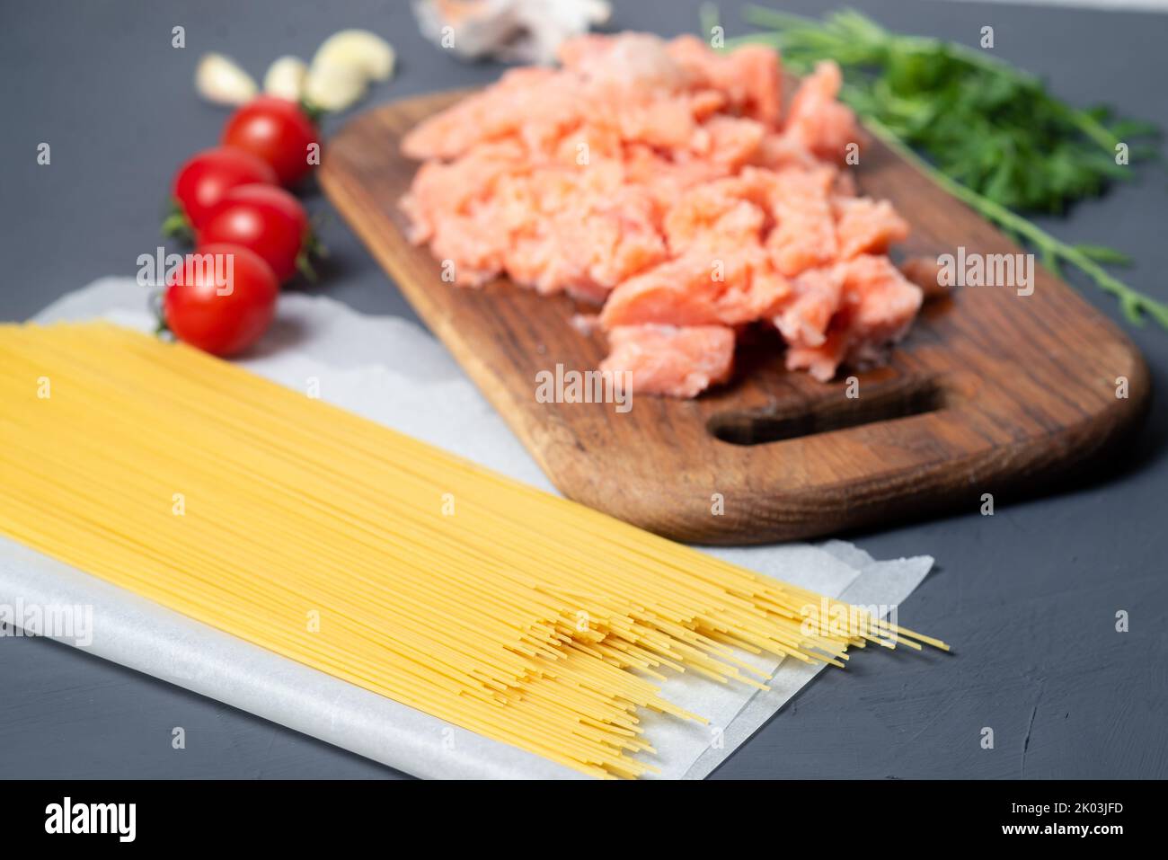 Cooking spaghetti with salmon and vegetables. Raw ingredients lie on a ...