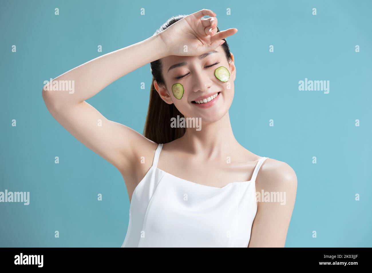 Beautiful young Chinese woman with cucumber slices Stock Photo - Alamy