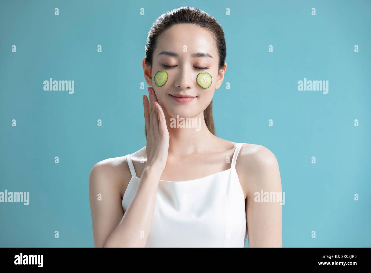 Beautiful young Chinese woman with cucumber slices Stock Photo - Alamy