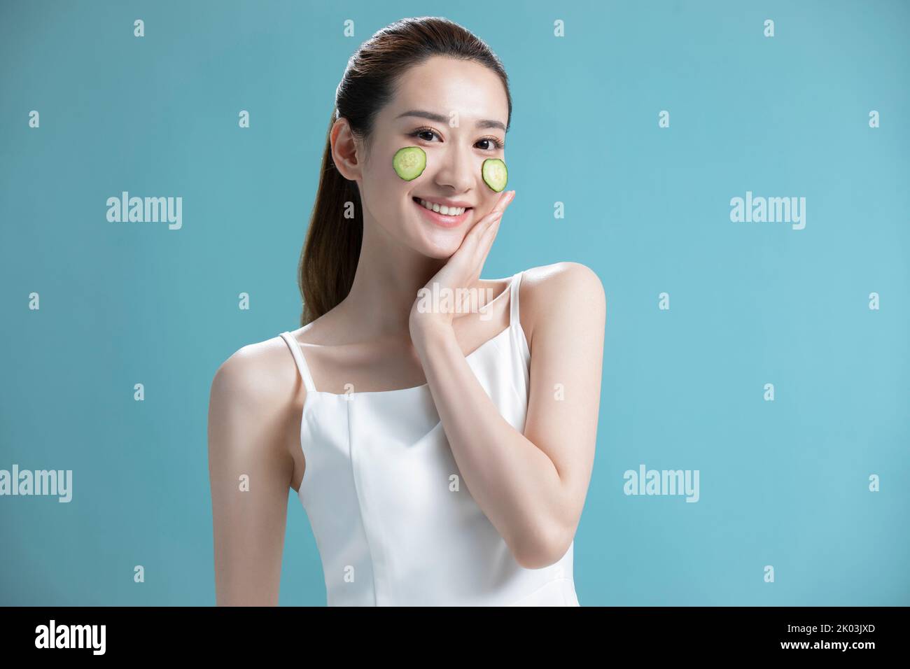 Beautiful young Chinese woman with cucumber slices Stock Photo - Alamy