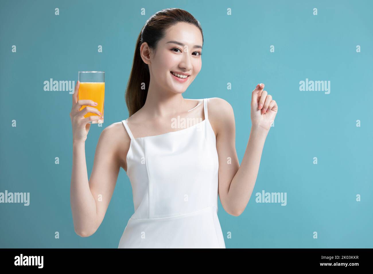 Beautiful young Chinese woman drinking orange juice Stock Photo - Alamy