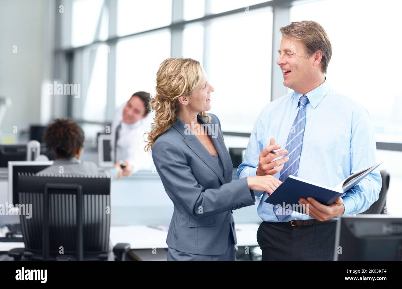 Sharing a little bit of office humour. Two happy mature business ...