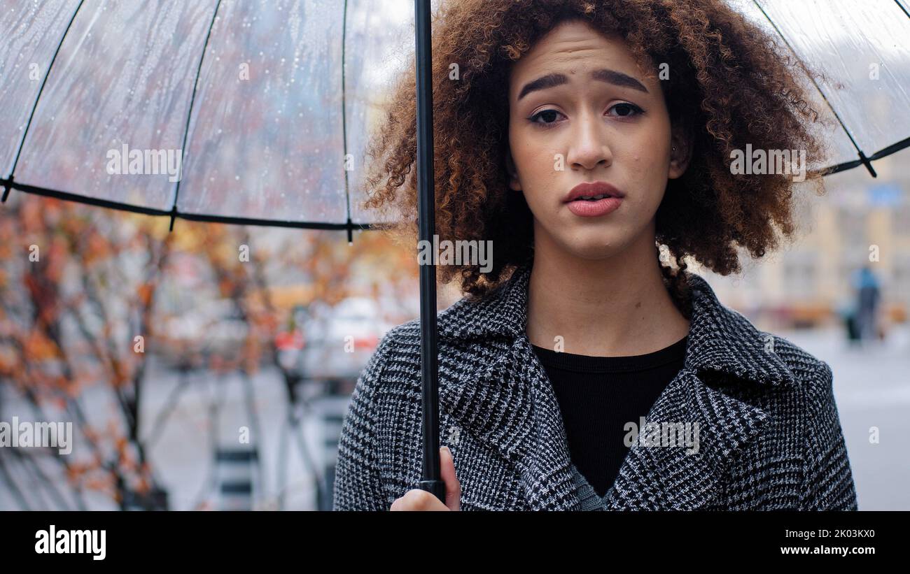 African American girl curly-haired sad woman in stylish coat stands in ...