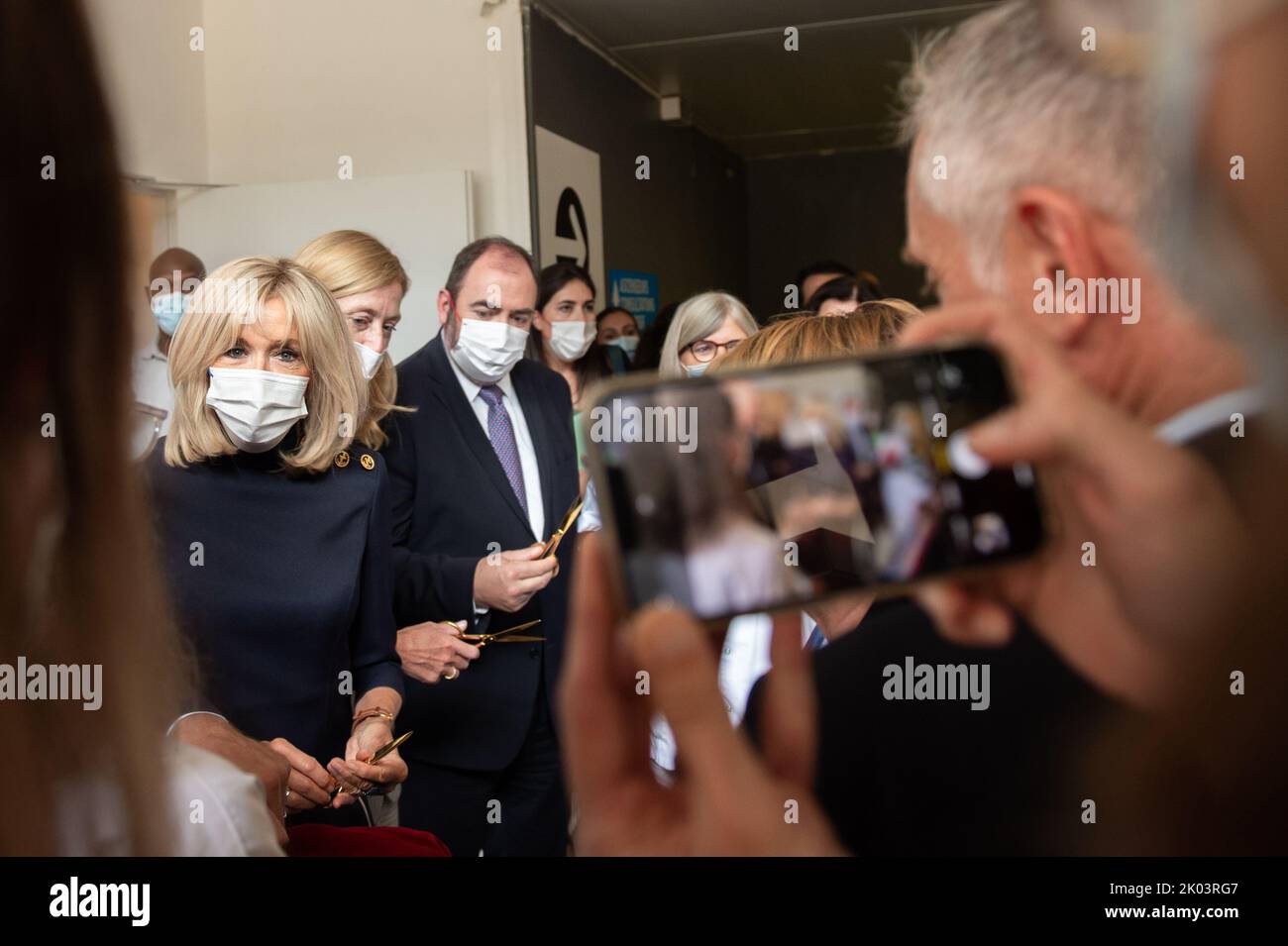 Brigitte Macron holds the scissors in her hand. The wife of the ...