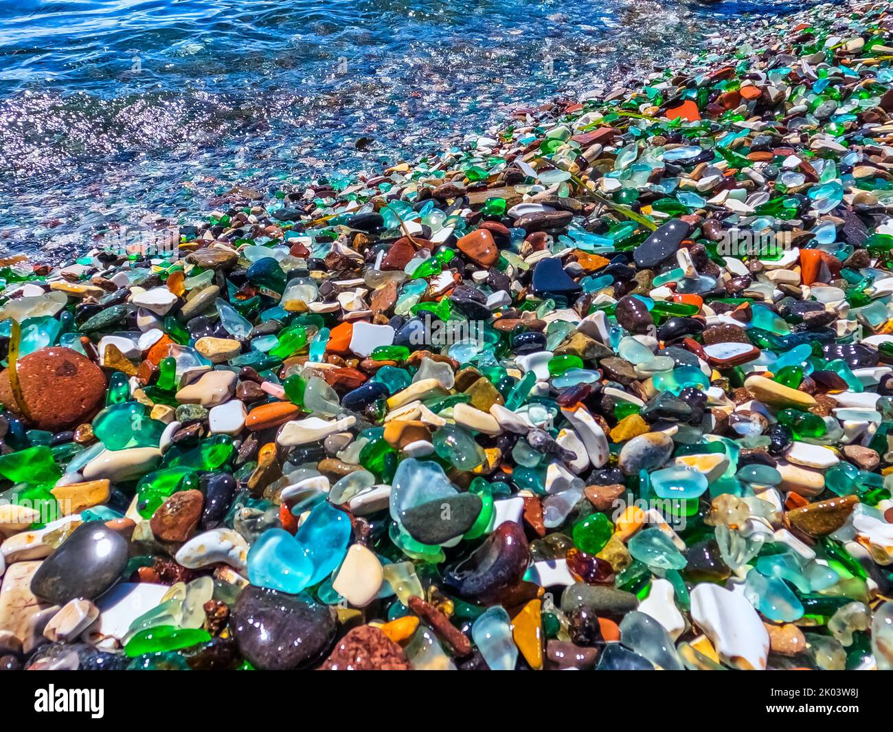 Natural polish textured sea glass and stones on the seashore. Azure ...