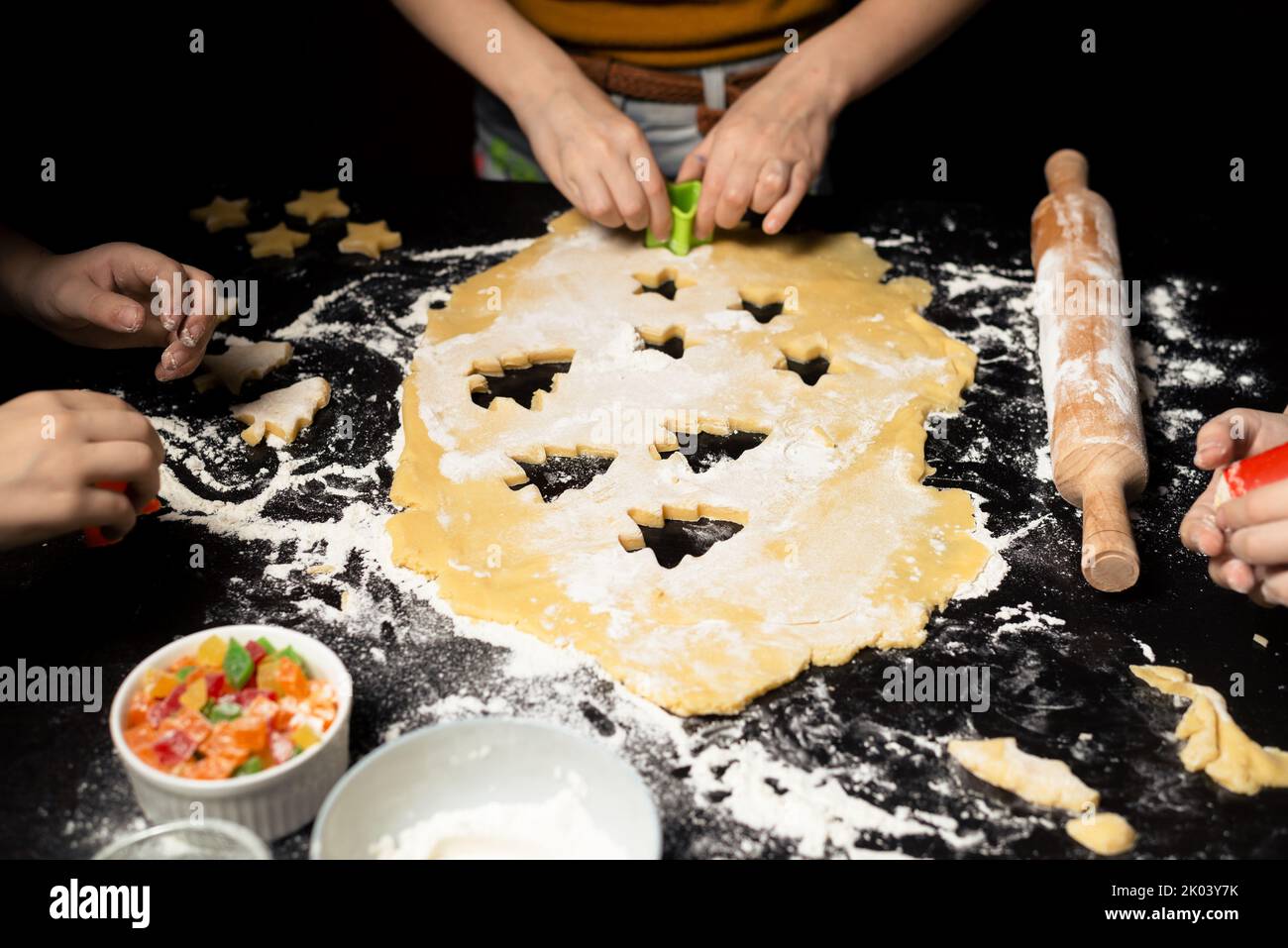 Children cook New Year's cookies together. Carving Christmas trees from ...