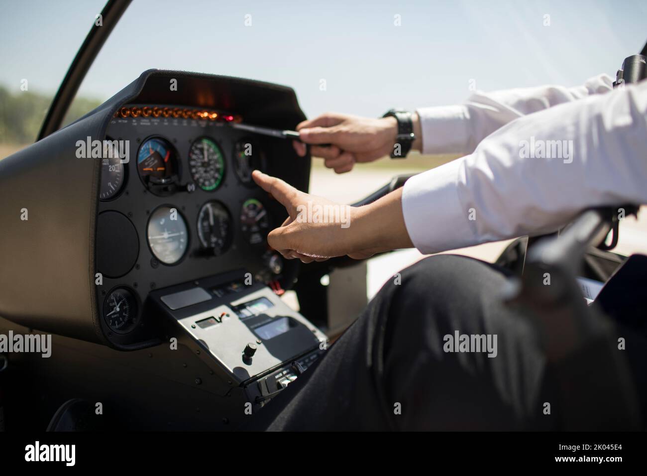 Chinese pilot teaching trainee to operate control panel in cockpit ...