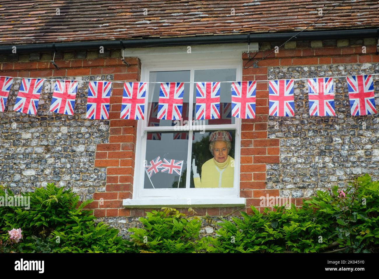 A hand-painted cut-out of Her Majesty Queen Elizabeth II looks down ...