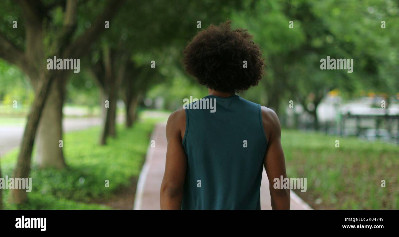 Back of african black man walking in nature pathway park Stock Photo ...