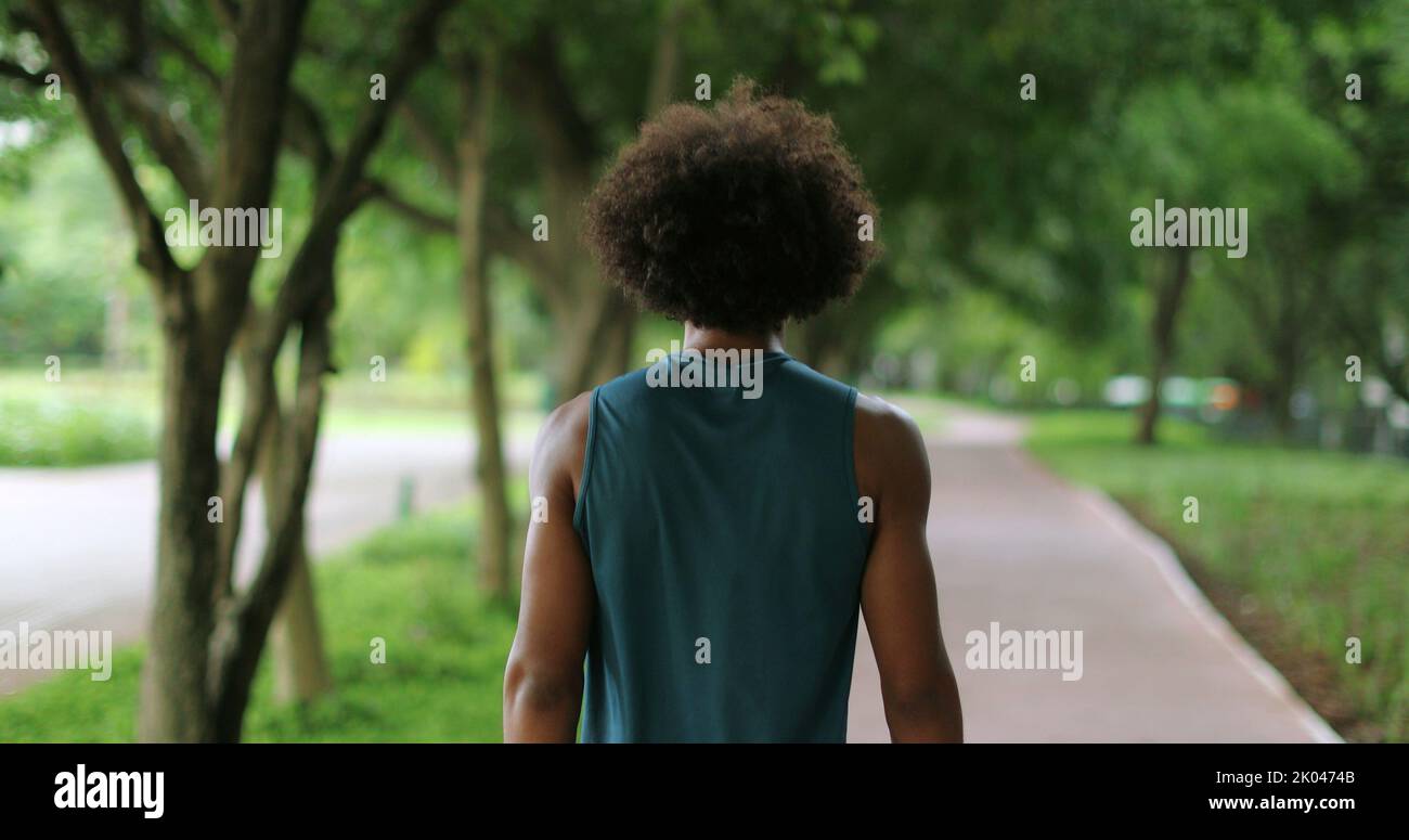 Back of african black man walking in nature pathway park Stock Photo ...
