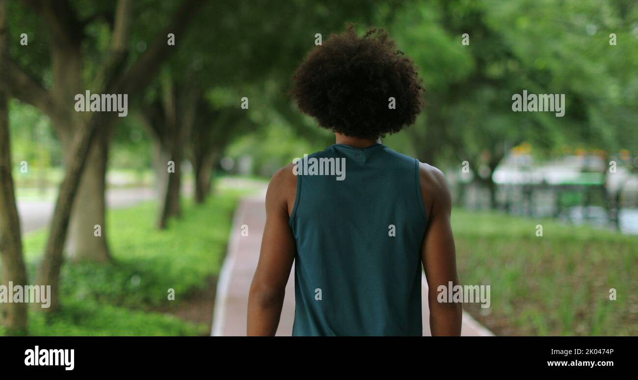 Back of african black man walking in nature pathway park Stock Photo ...
