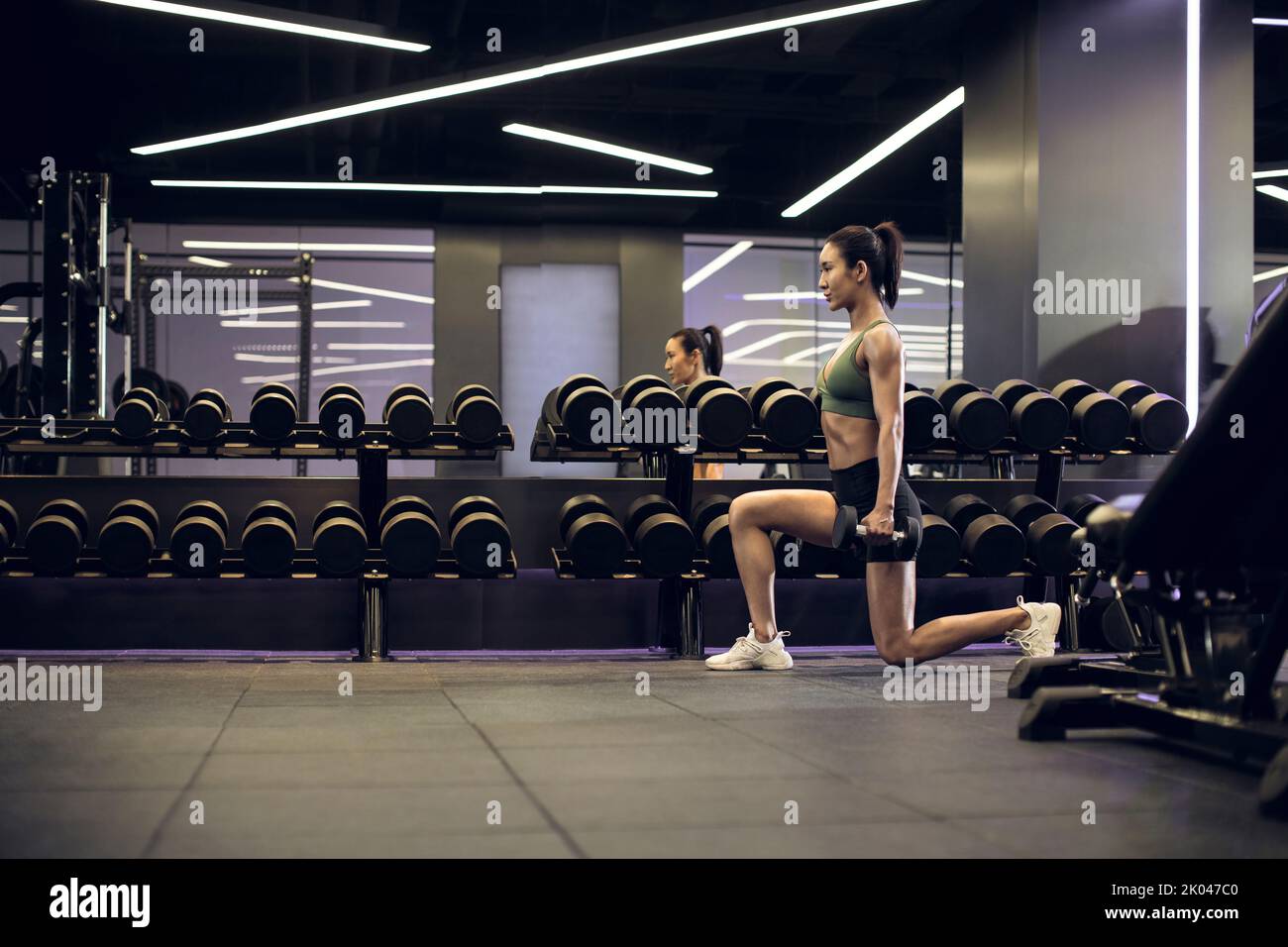 Young Chinese woman working out with dumbbell at gym Stock Photo - Alamy