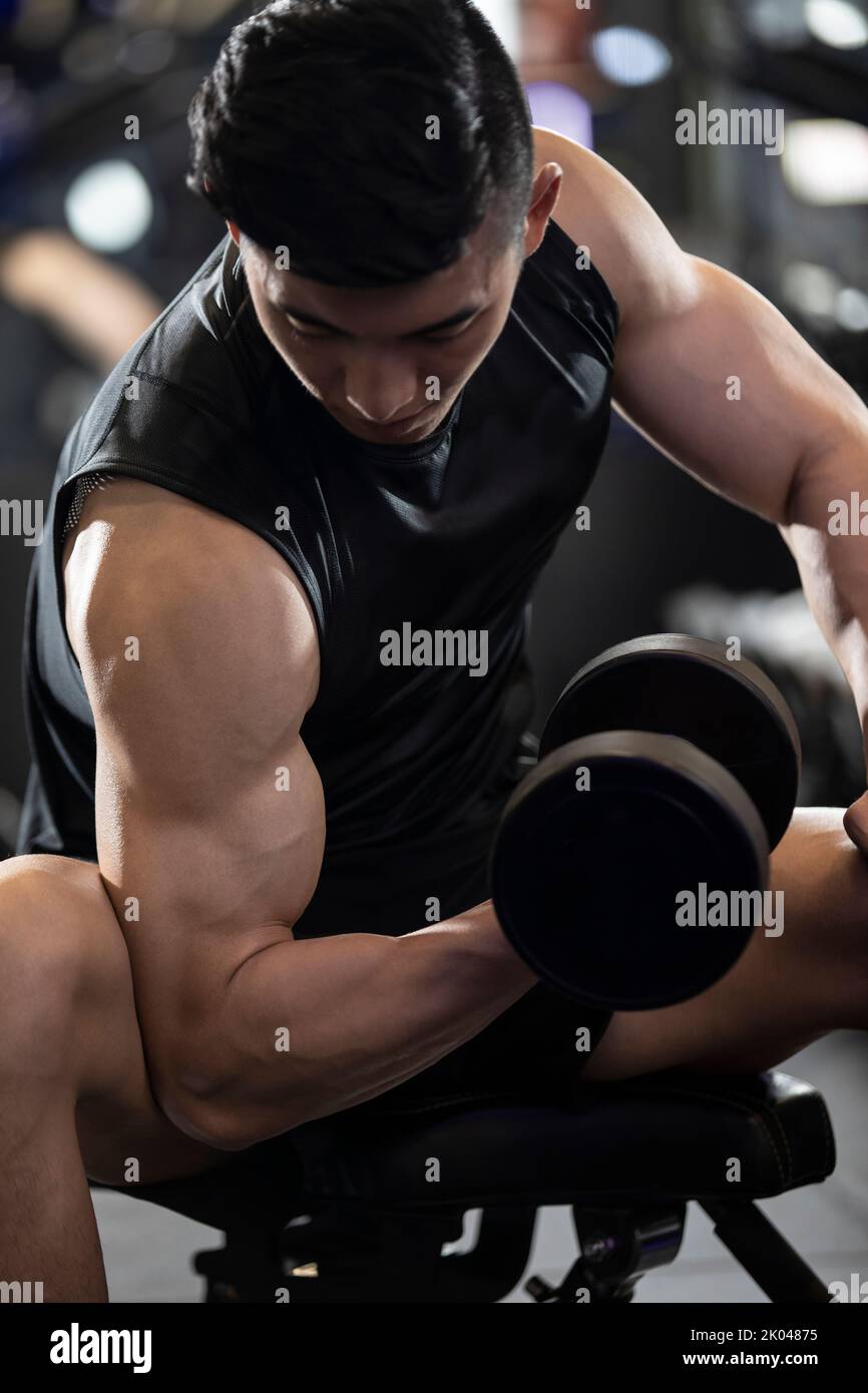 Young Chinese man working out with dumbbell at gym Stock Photo - Alamy