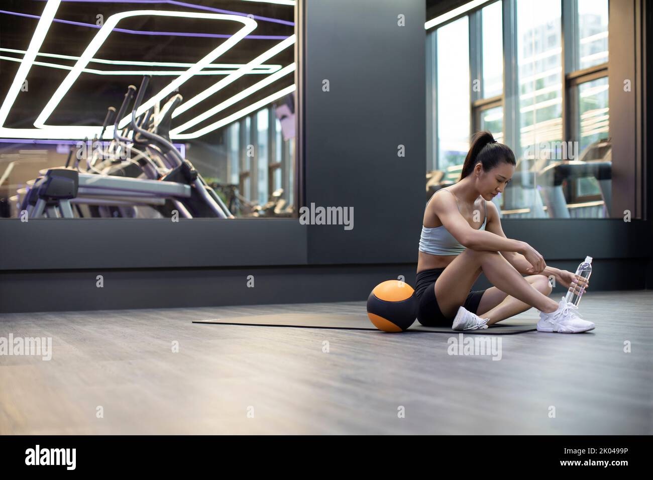 Young Chinese woman taking a break from workout at gym Stock Photo - Alamy