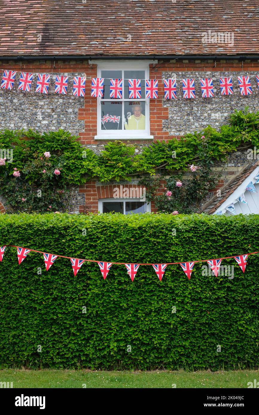 A hand-painted cut-out of Her Majesty Queen Elizabeth II looks down ...