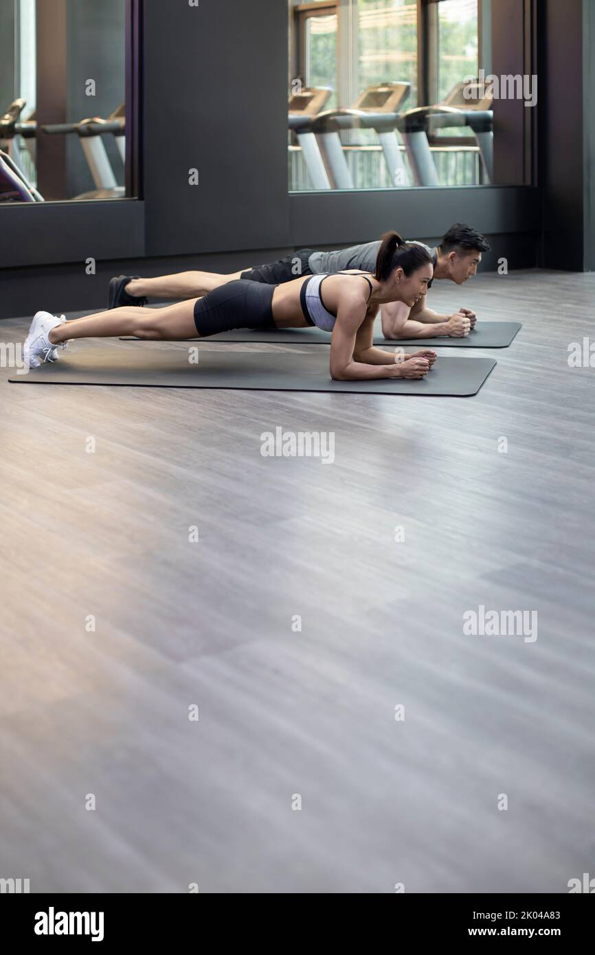 Young Chinese couple exercising at gym Stock Photo - Alamy