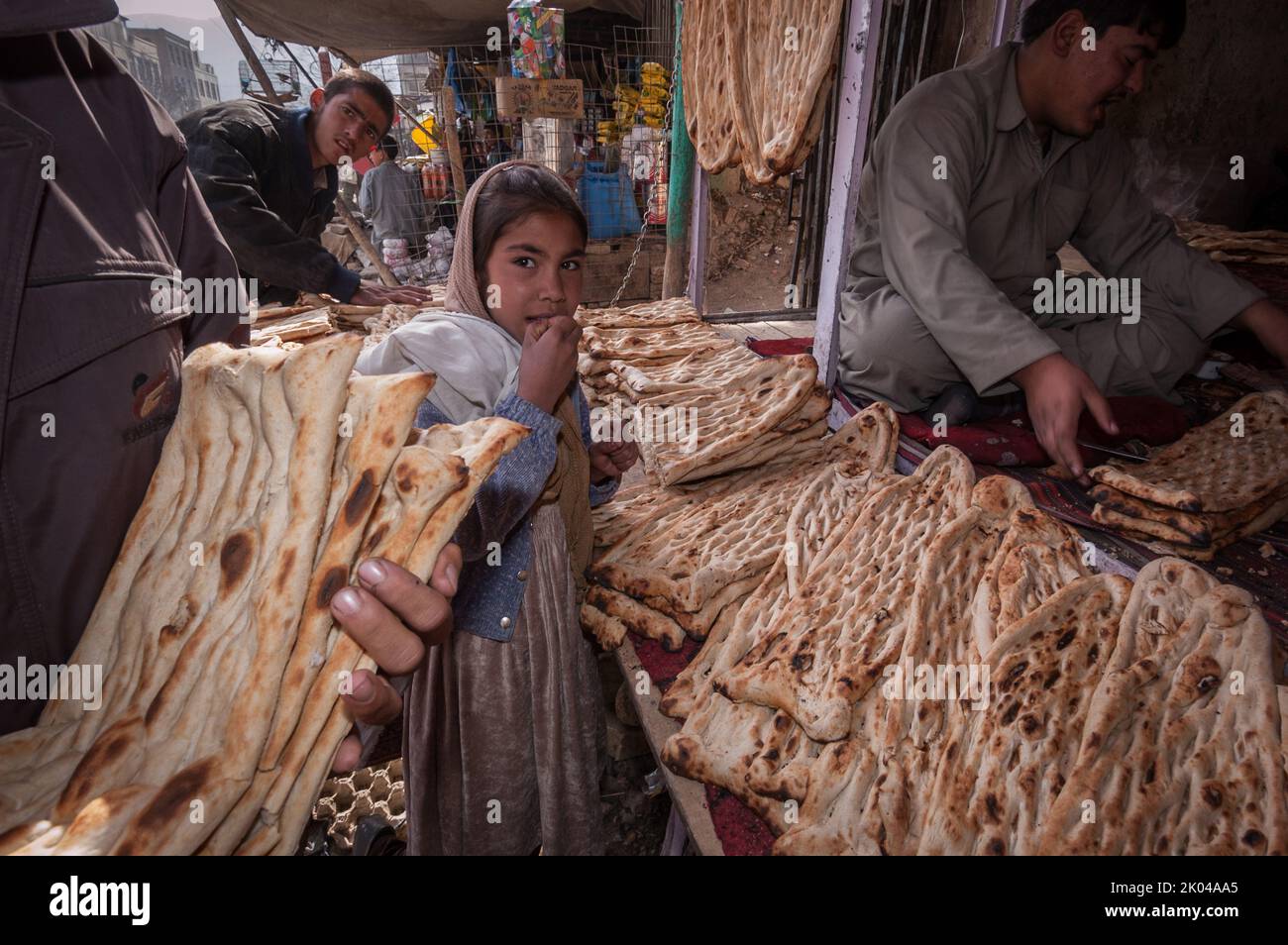 Kabul, Afghanistan - November 2004: Girl buying bread from Kabul bakery ...