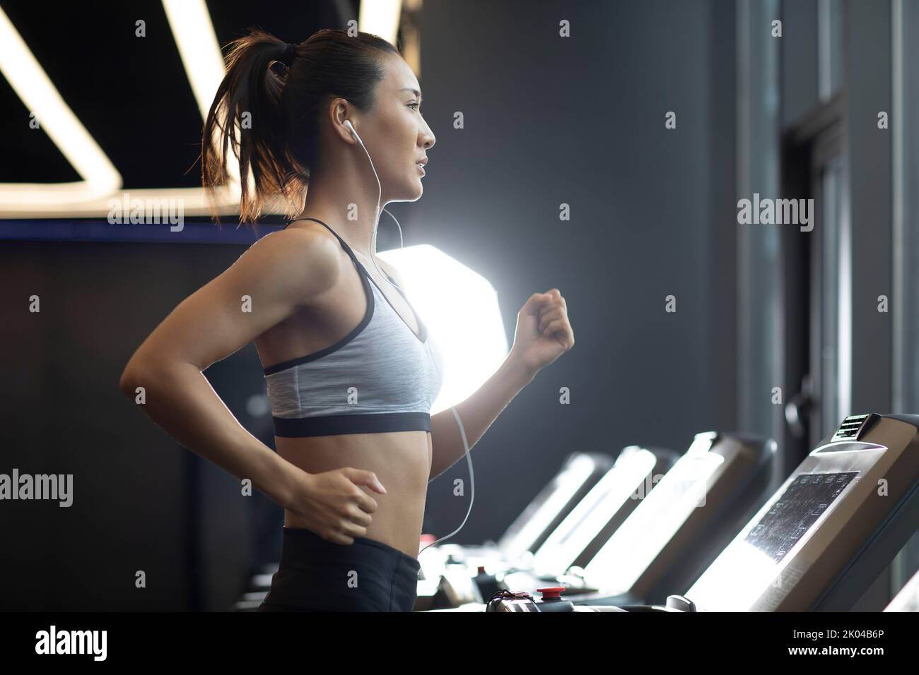 Young Chinese woman running on treadmill at gym Stock Photo - Alamy